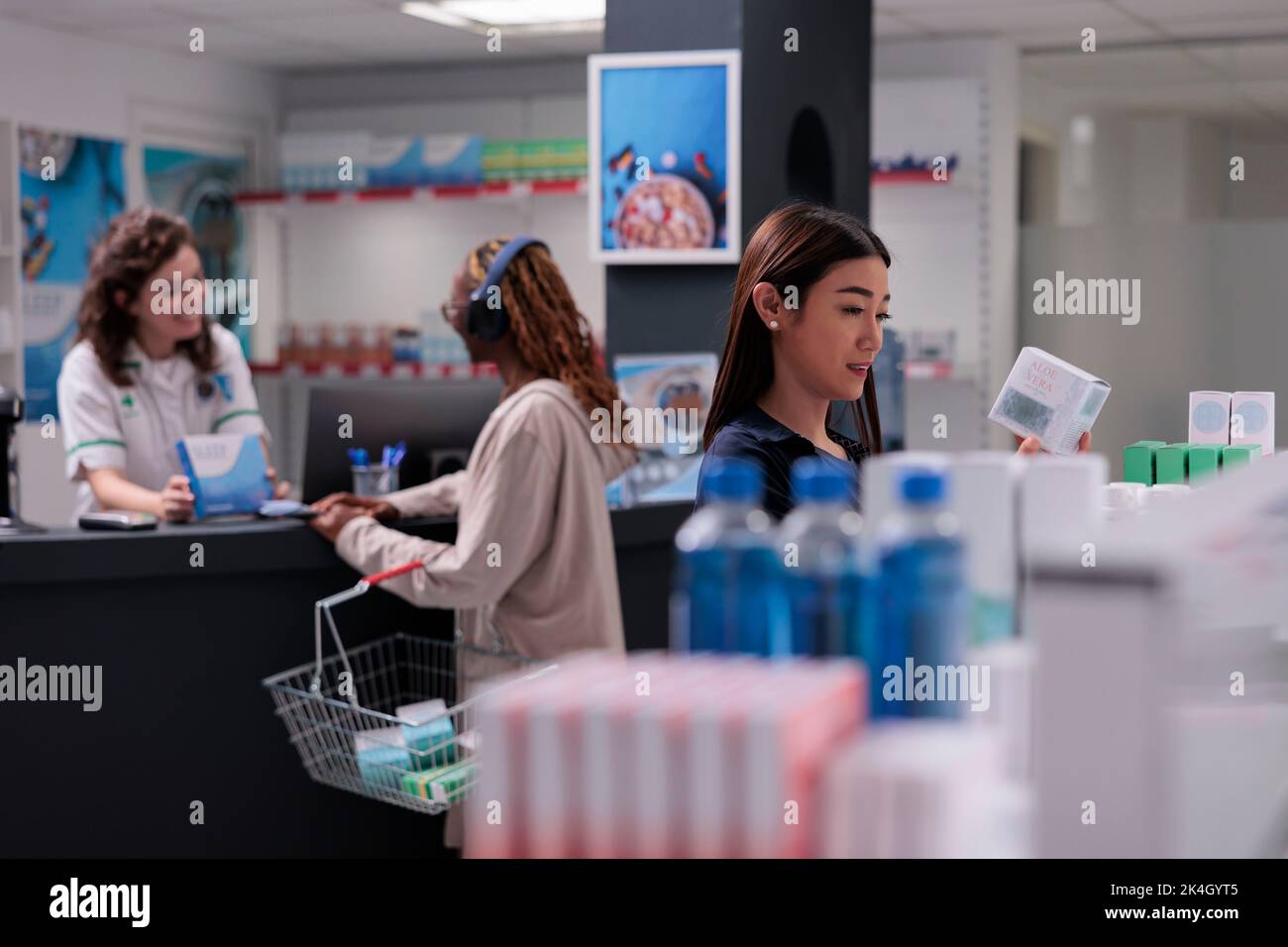 Clients looking at shelves full with pharmaceutical pills, buying ...