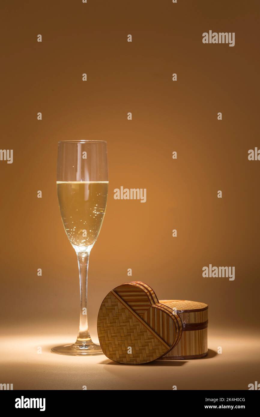 view of a glass of cava and two boxes, the one we see in front has the ...