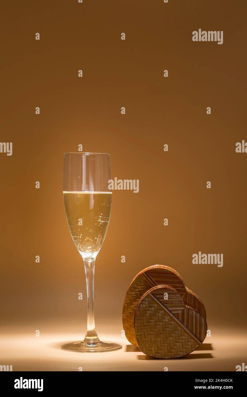 view of a glass of cava and two boxes, the one we see in front has the ...