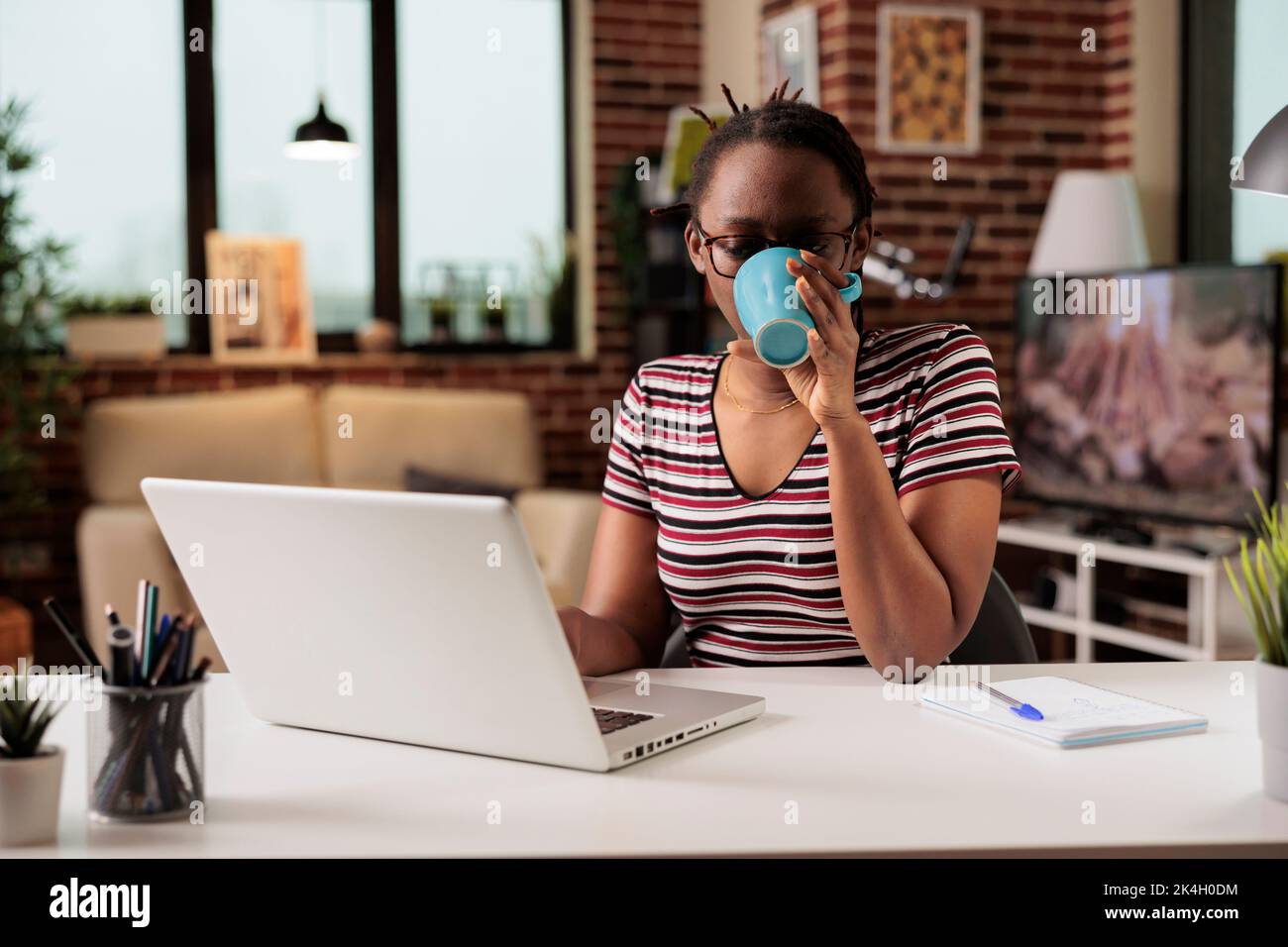 Remote student watching educational tutorial on laptop at home ...
