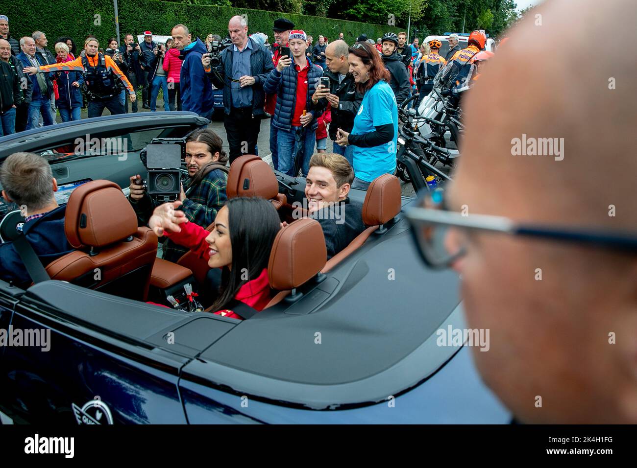 Remco Evenepoel's partner Oumaima Oumi Rayane sits in a convertible car ...