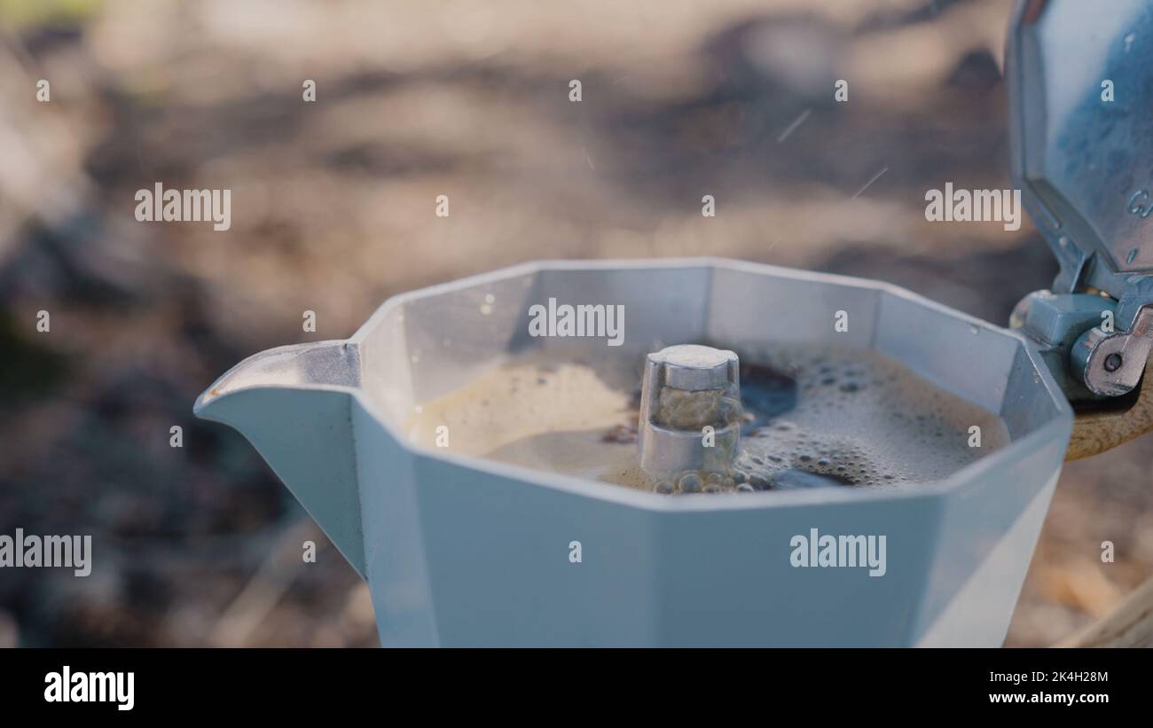 Coffee boils in geyser coffee maker kettle on blurry grey background ...