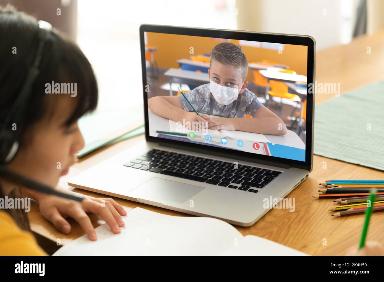 Asian girl using laptop for video call, with elementary school pupil ...