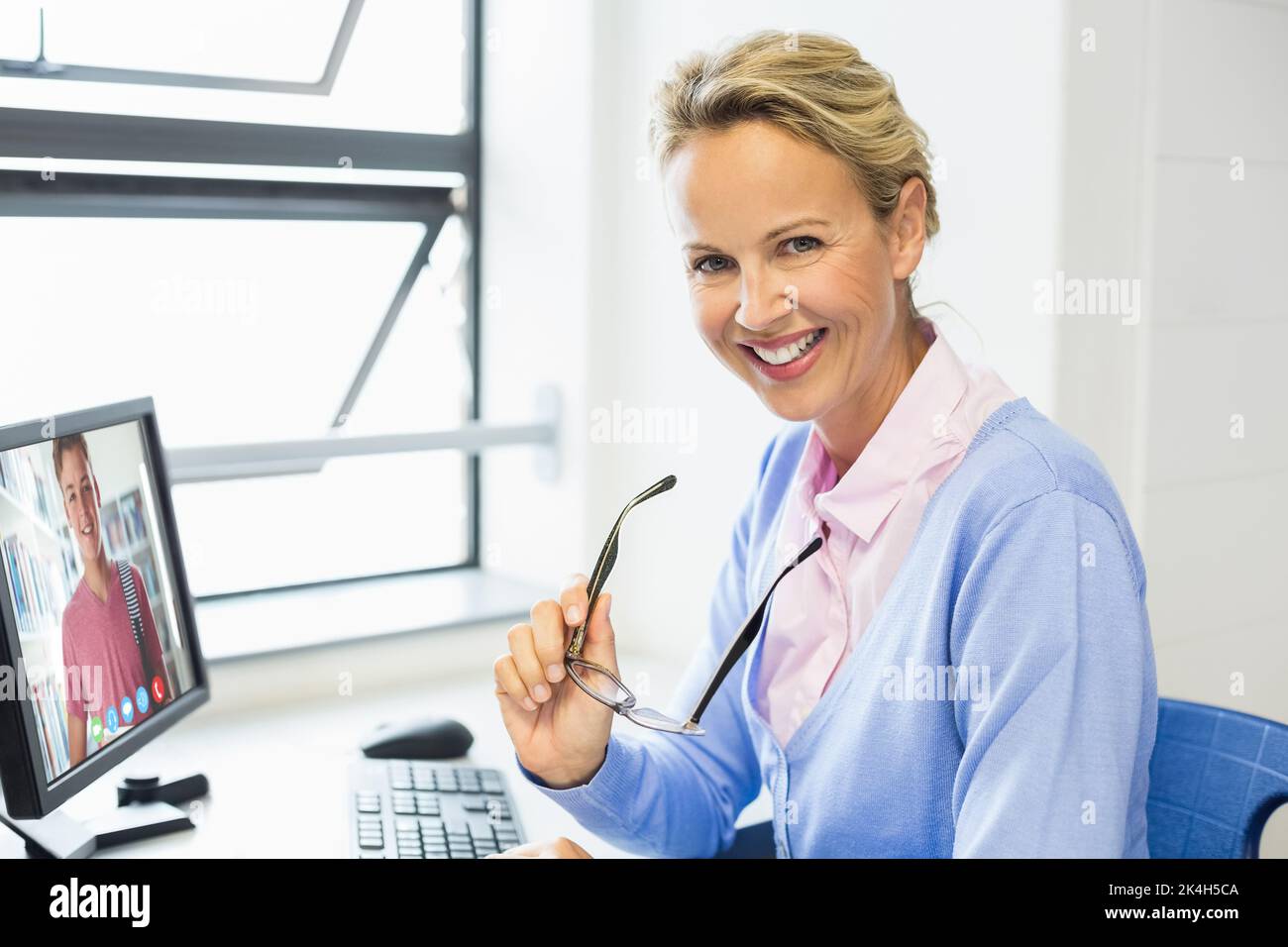 Portrait of female caucasian teacher having a video call with male ...