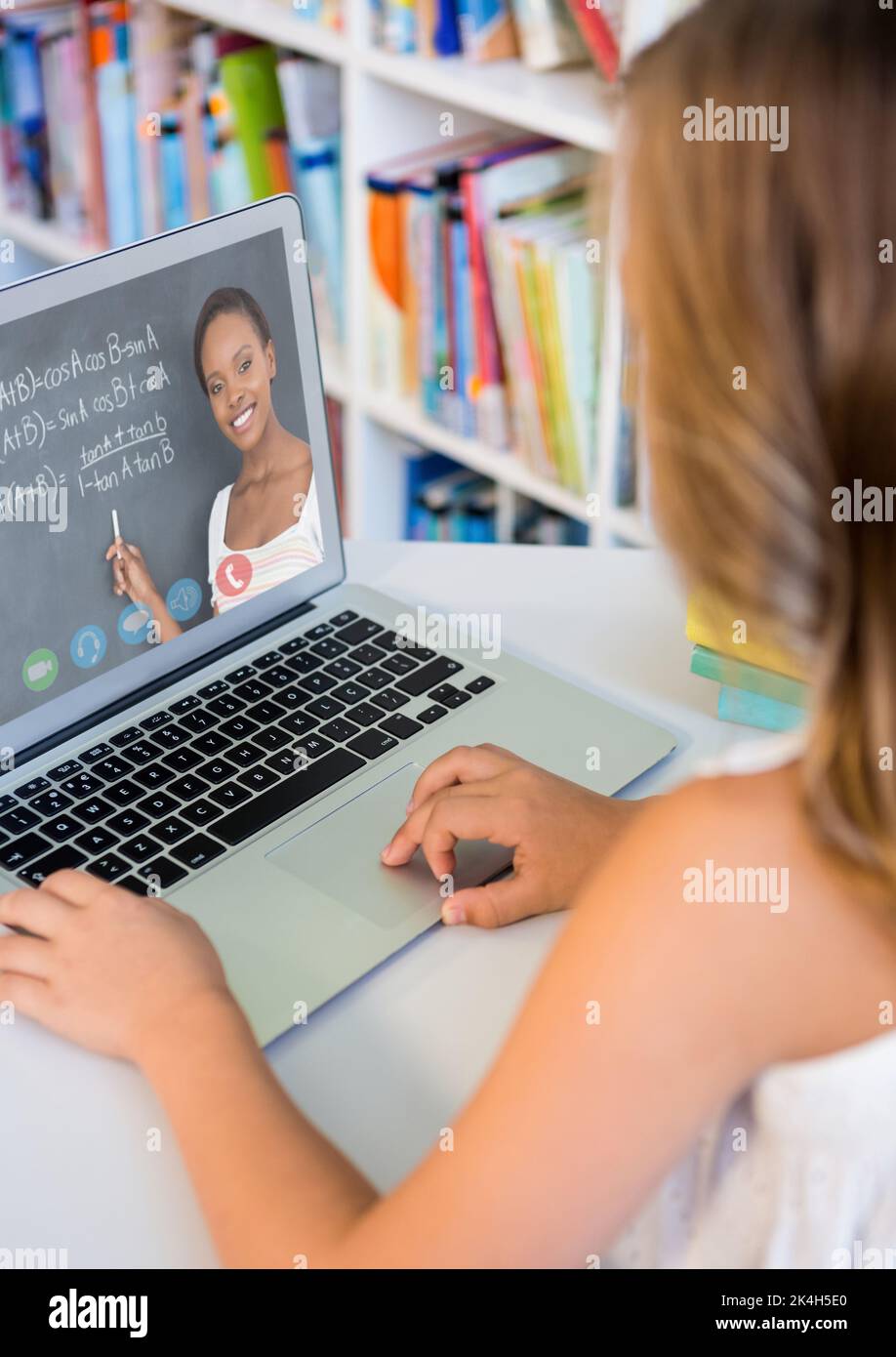 Female student having a videocall with female teacher on laptop at home ...