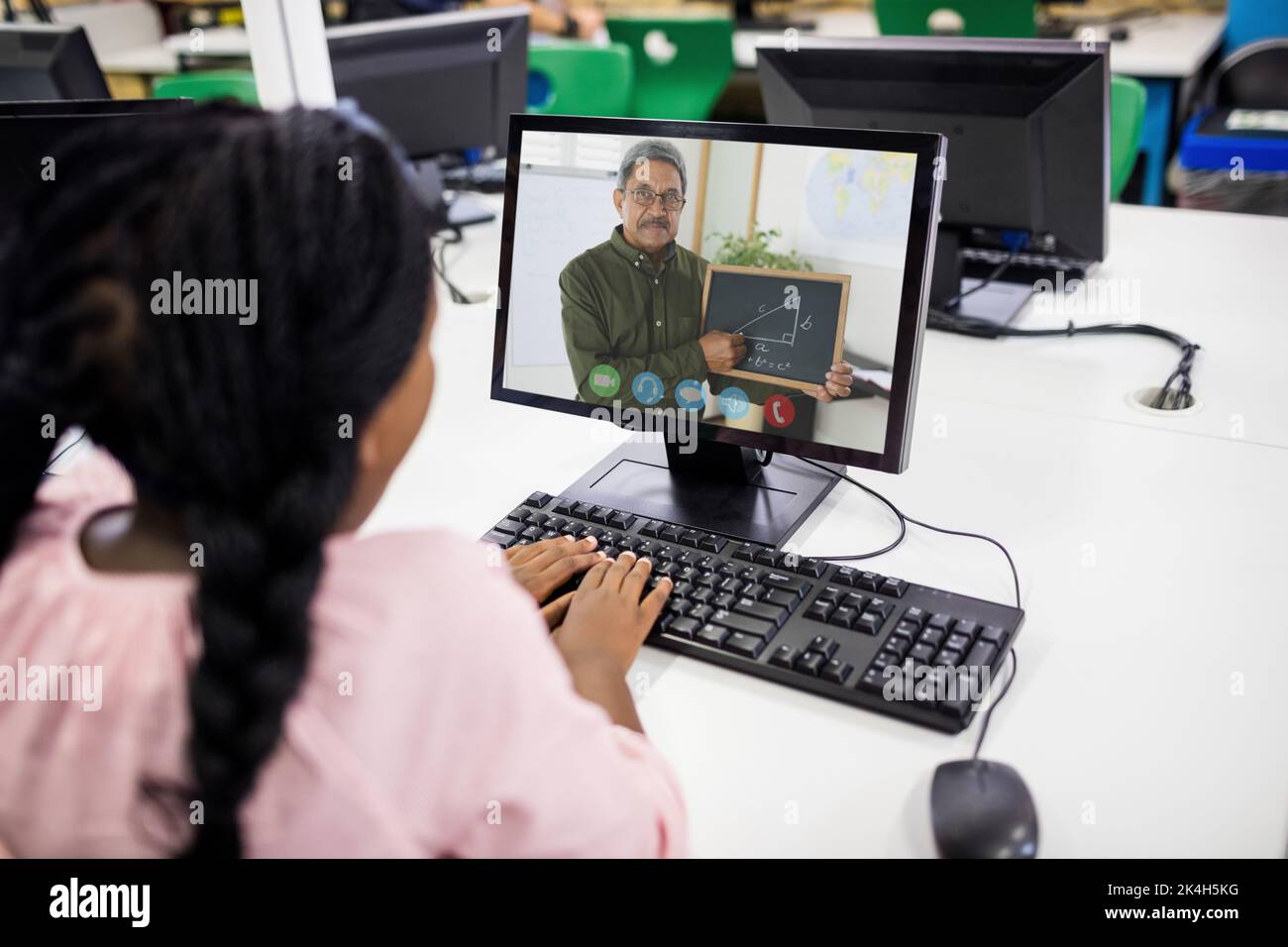 Female student having a video call with male teacher on computer at ...