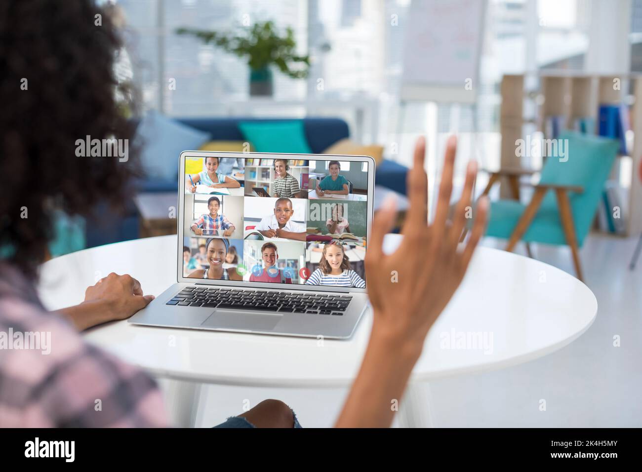 Female teacher having a video conference with multiple students on ...