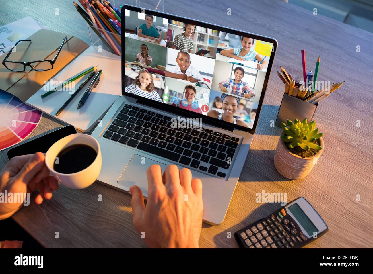 Mid section of teacher having a video conference with multiple students ...