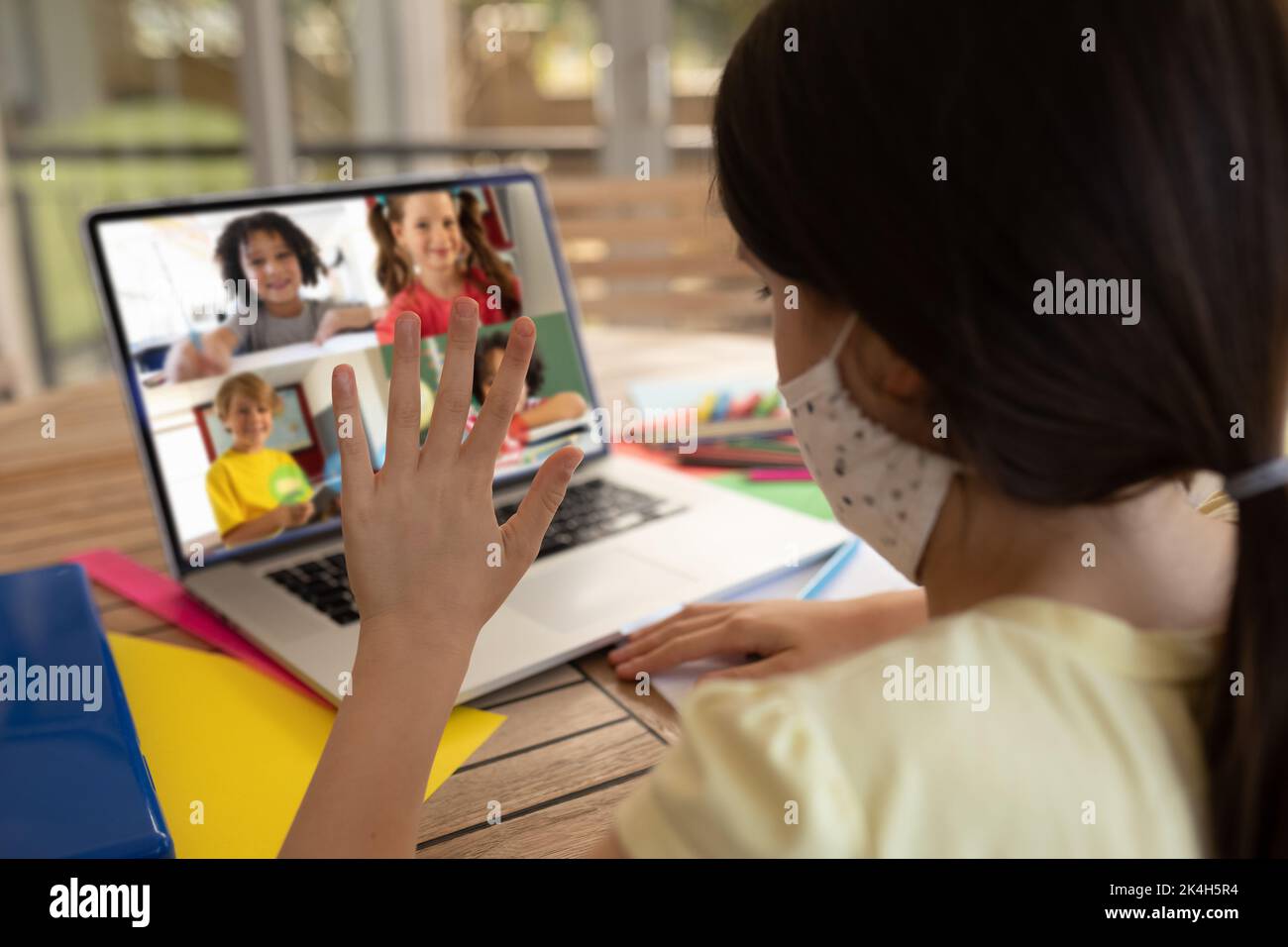 Female student wearing face mask having a video conference with ...