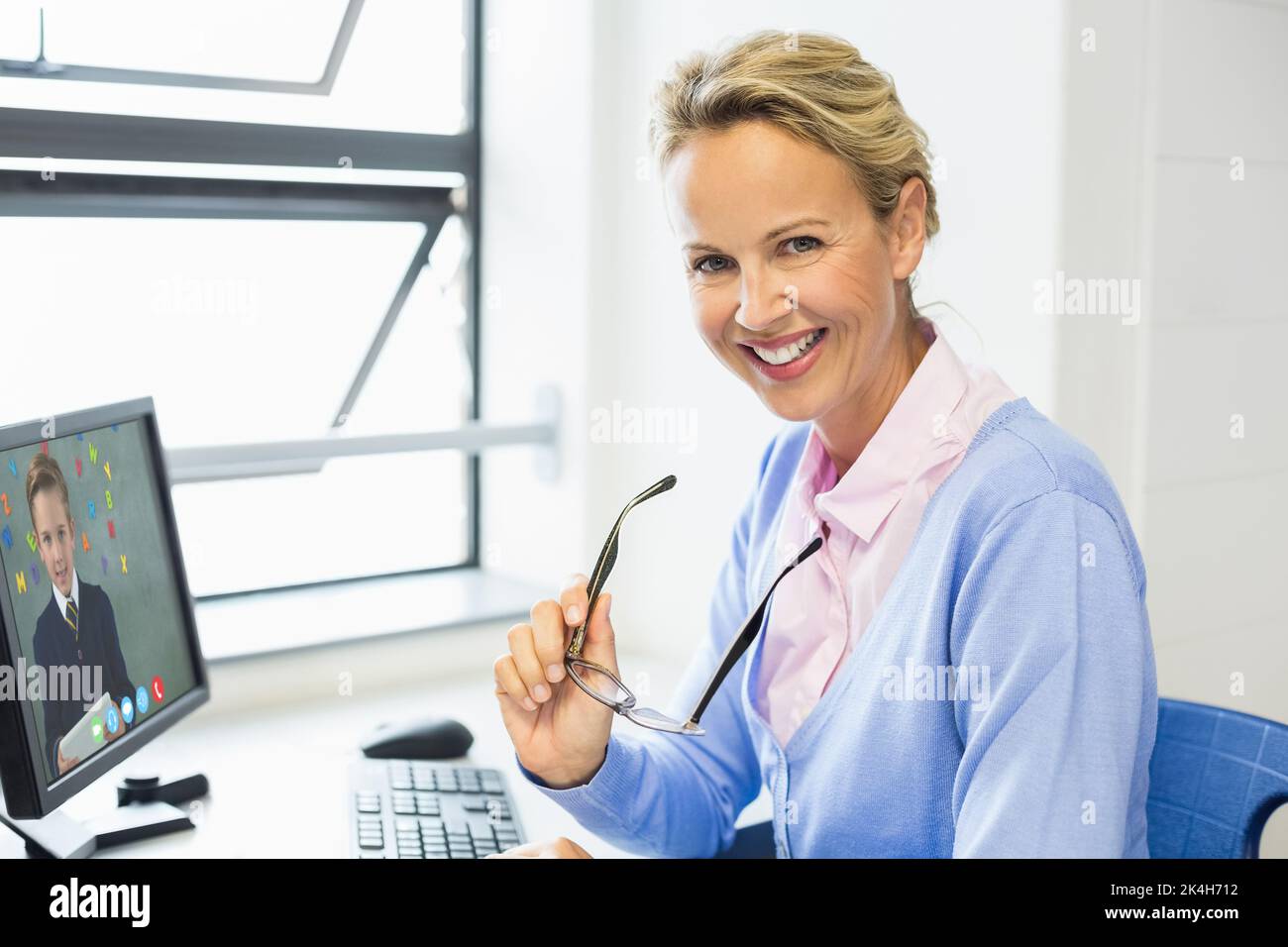 Portrait of happy caucasian female teacher using computer on video call ...