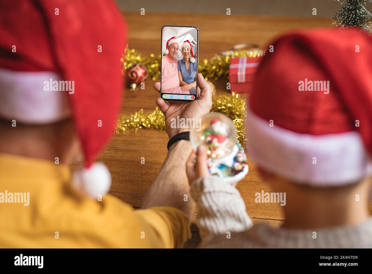 Caucasian father and son in santa hats on smartphone christmas video ...
