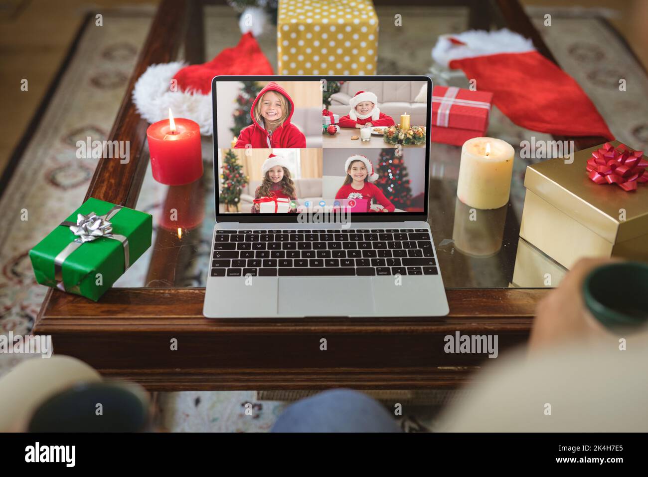 Four smiling caucasian children in santa hats on laptop christmas group ...