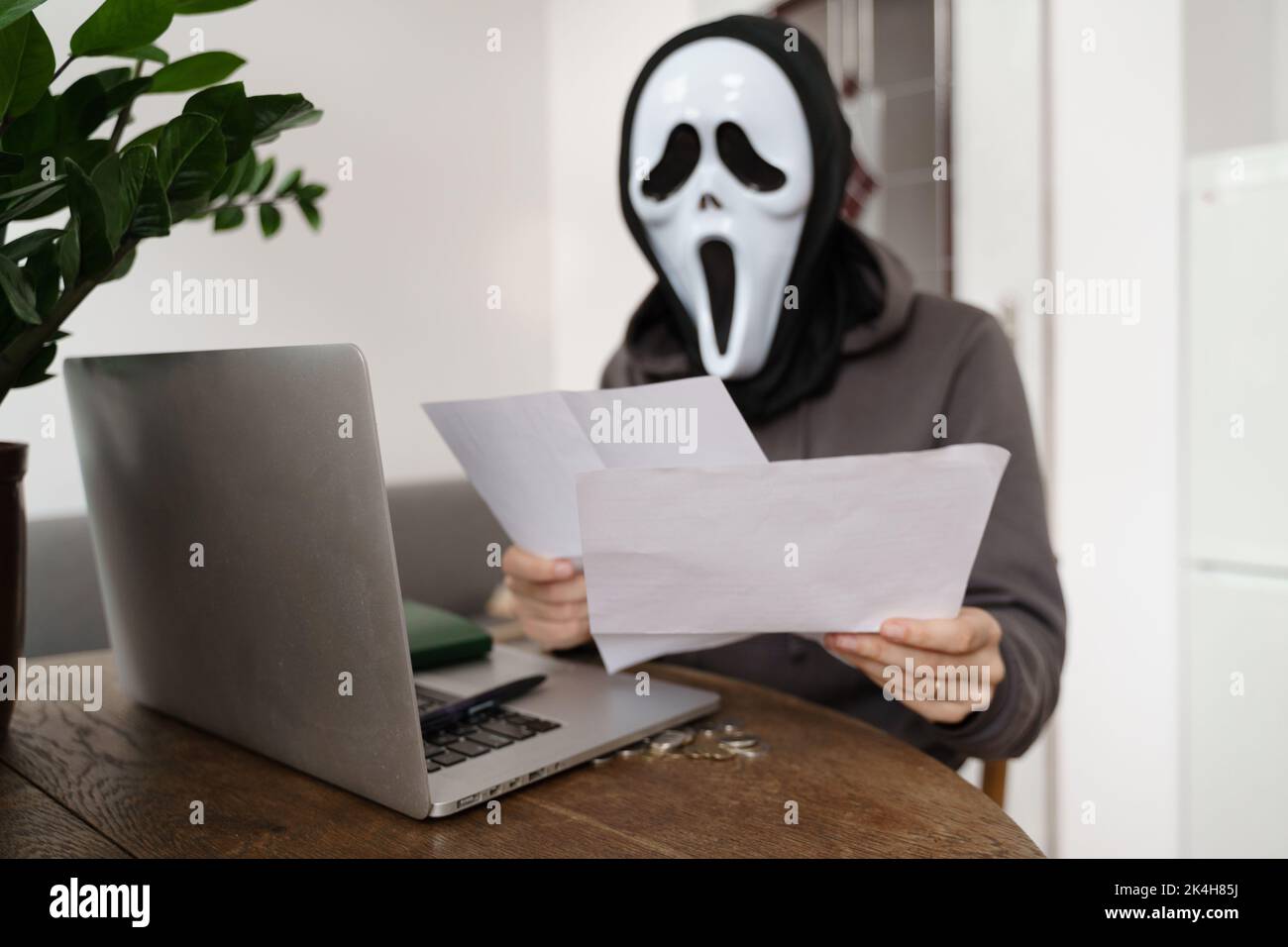 Anonymous person with ghost mask checking papers. Energy crisis and ...