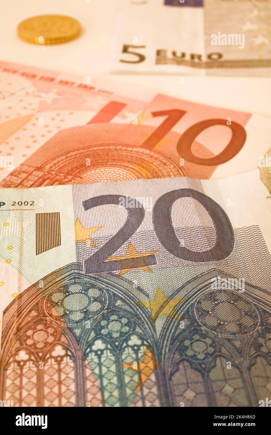 Close-up of 5, 10, 20 Euro currency banknotes and coin on white ...