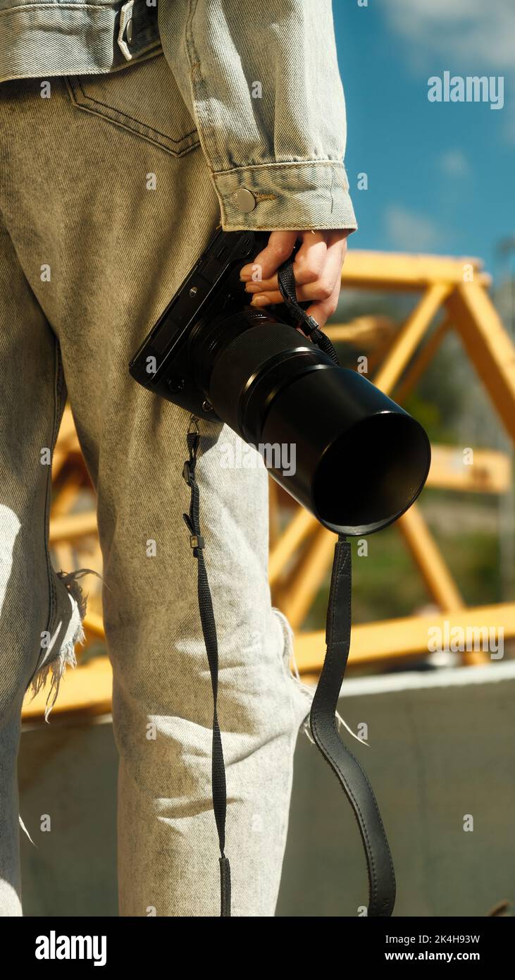 An unknown photographer holds the camera in his lowered right hand ...
