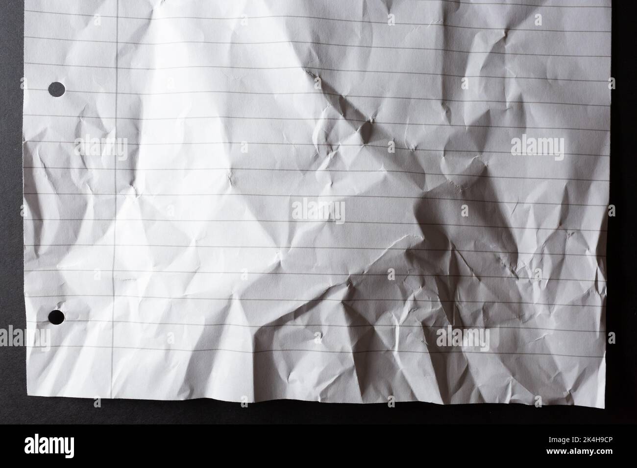 Scrunched up, hole punched sheet of lined white notebook paper, on ...