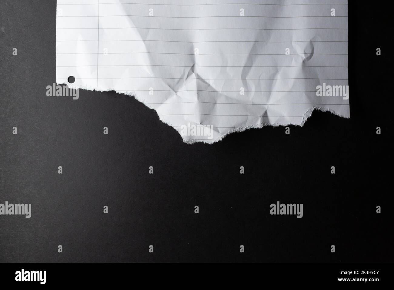 Torn scrunched up, hole punched sheet of lined white notebook paper, on ...