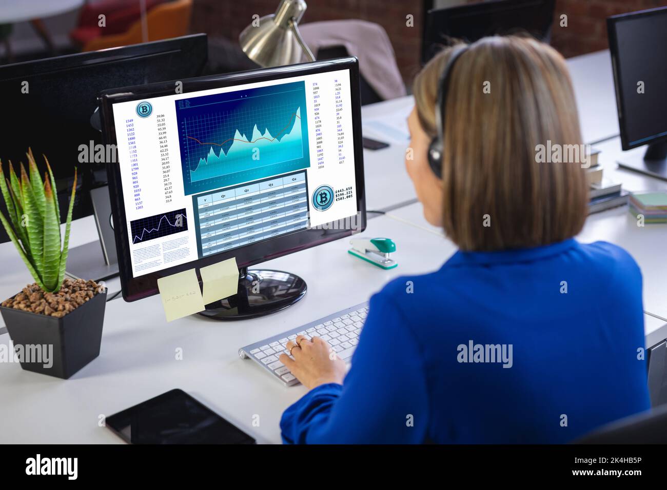 Caucasian businesswoman sitting at desk, using computer with ...