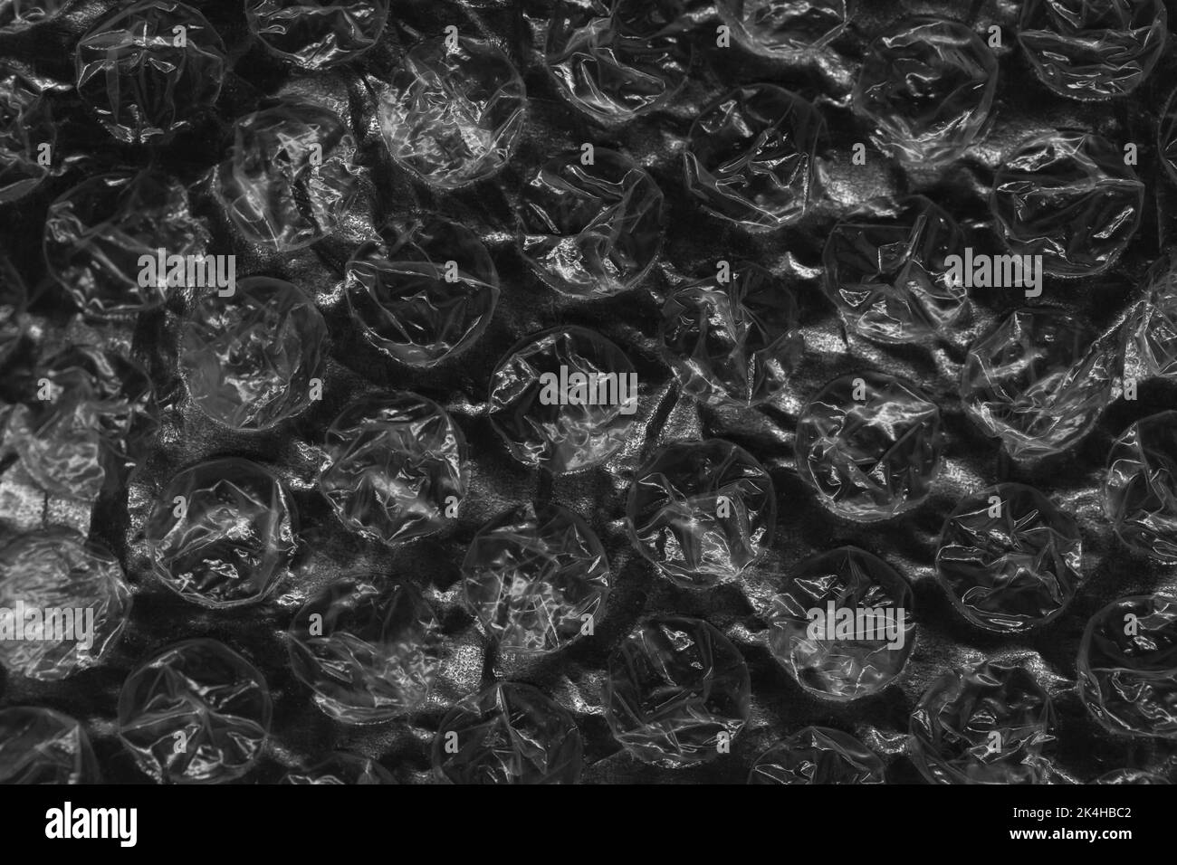 Reflecting light and shadow on creases and tears in plastic bubble wrap ...