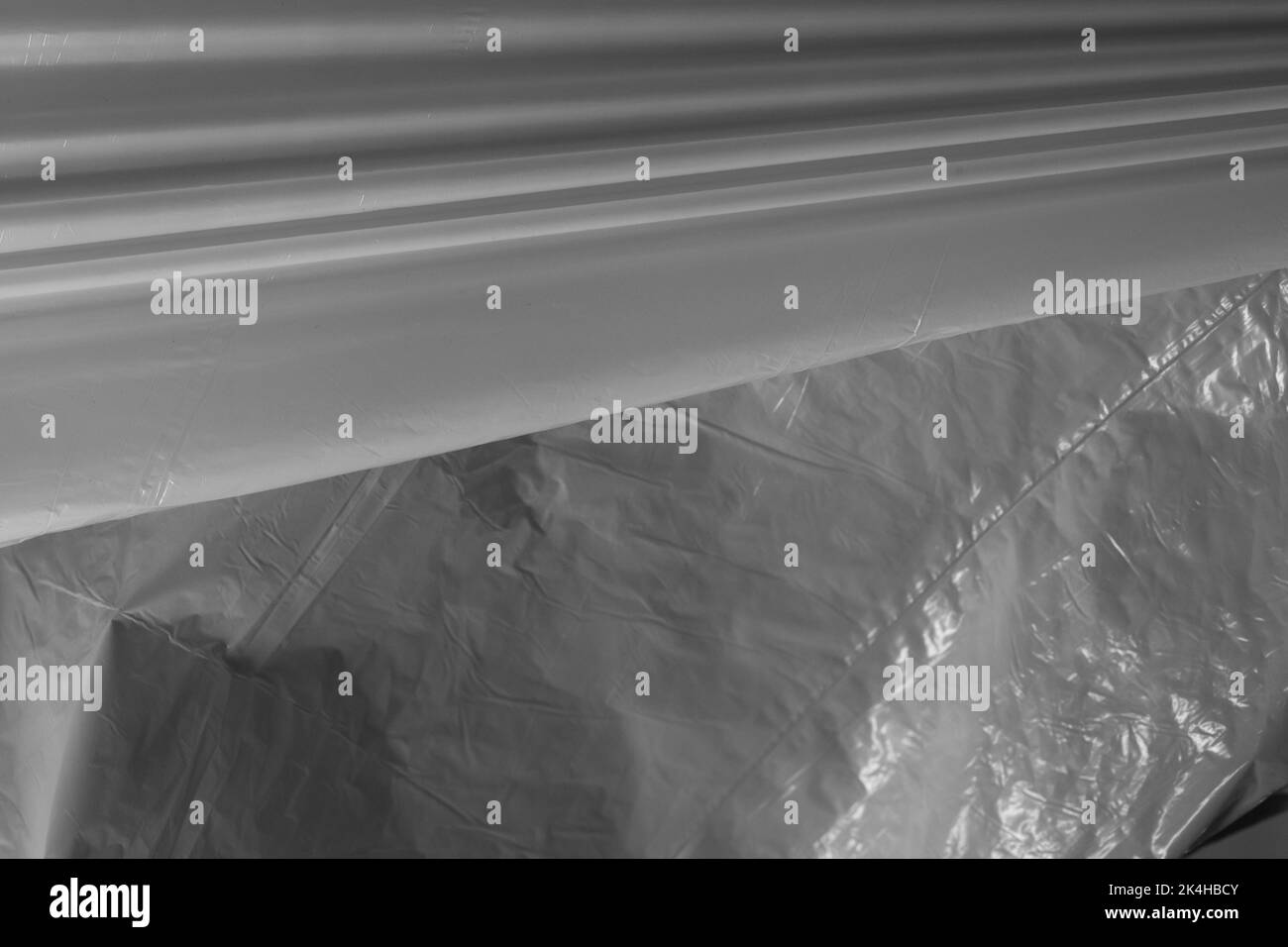 Lines of reflecting light and shadow on pleats and creases in plastic ...