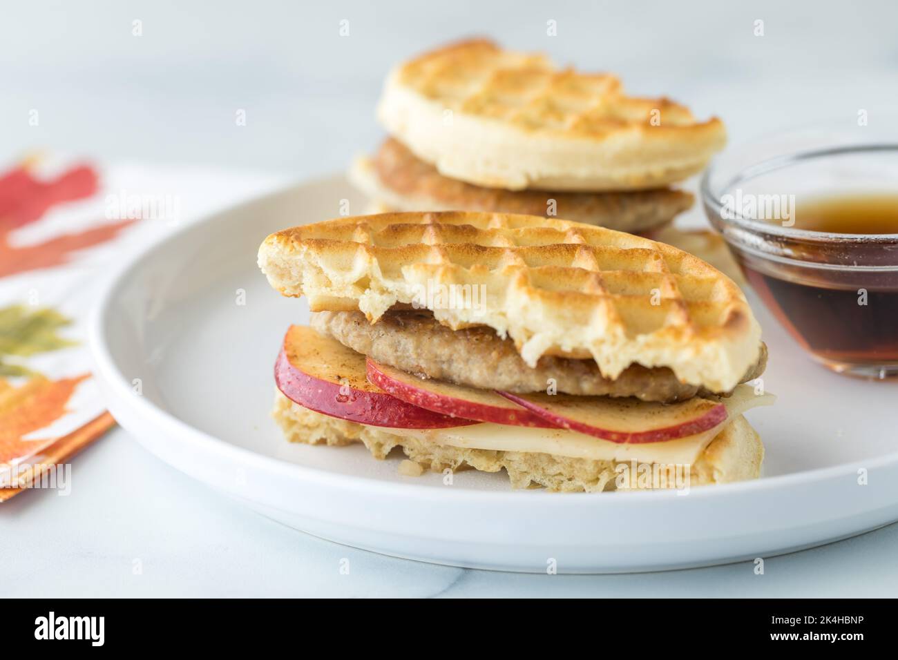 Waffle, apple and sausage sandwich served with maple syrup for dipping ...