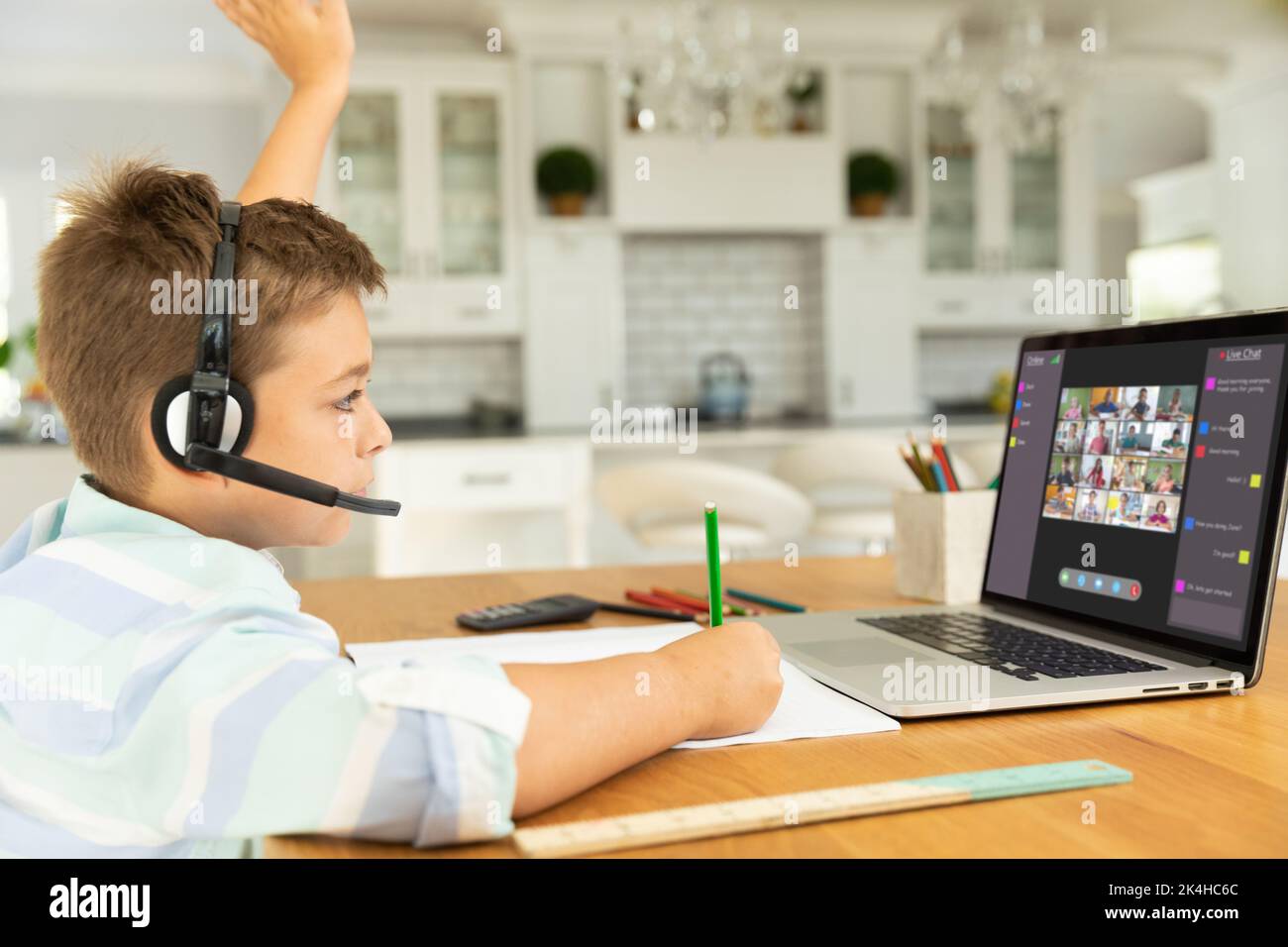 Caucasian boy raising hand for video call, with smiling diverse ...