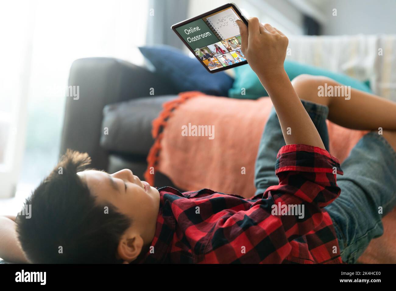 Asian boy using tablet for video call, with smiling diverse elementary ...