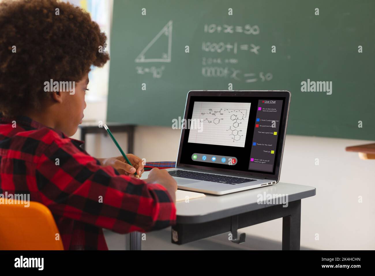 African american boy using laptop for video call, with class on screen ...