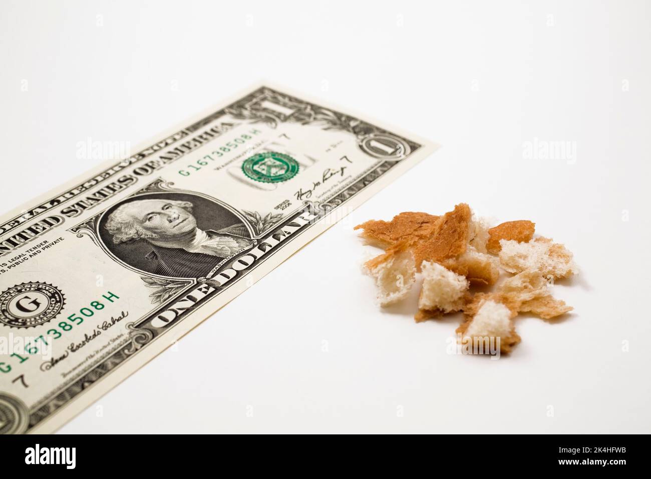 US one dollar bill next to some bread crumbs Stock Photo - Alamy