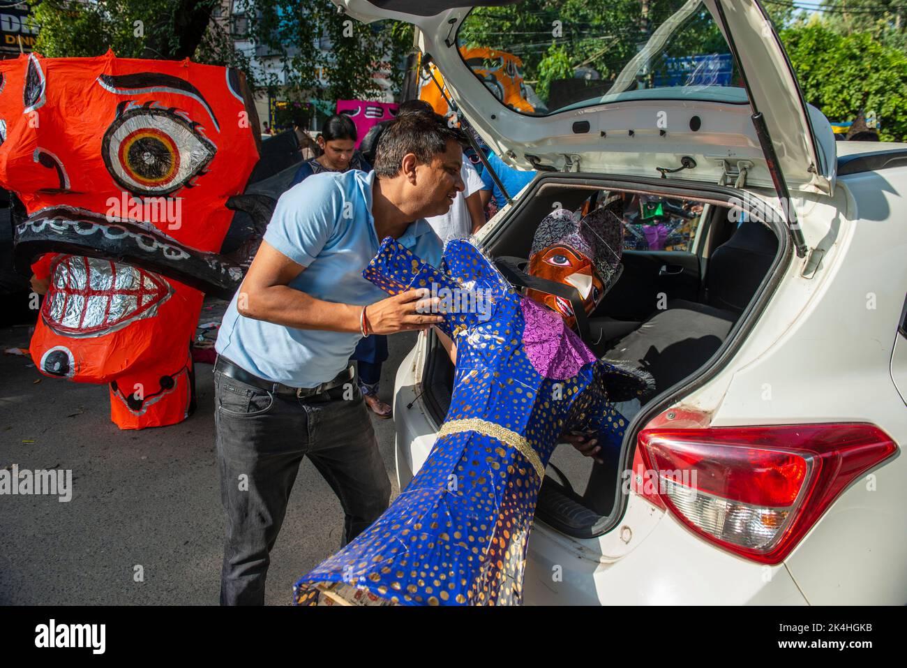 A man loads an effigy of Ravana in the back of a car ahead of Dussehra ...