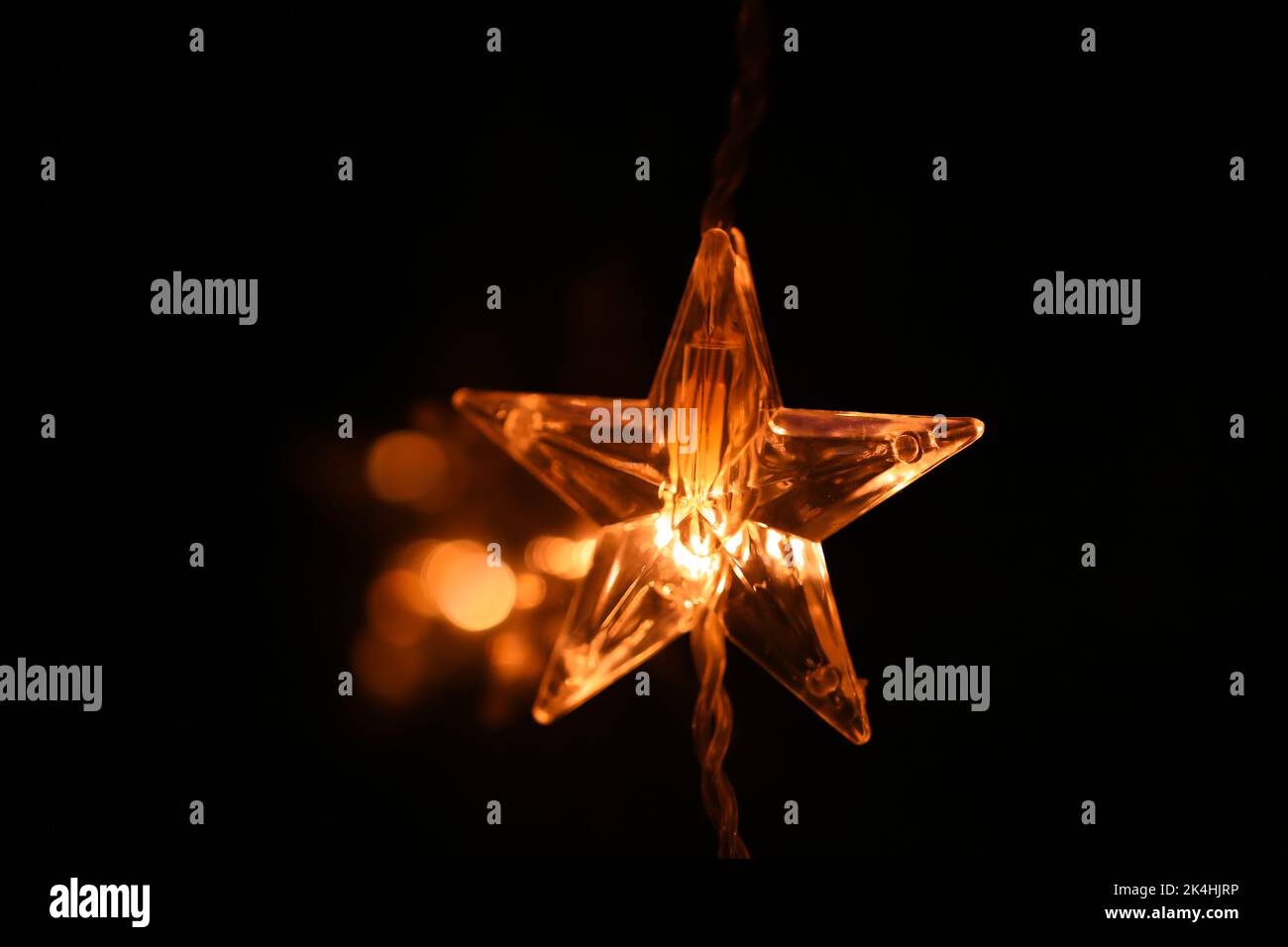 Star burning on a black background.Christmas wallpaper.glowing garlands ...