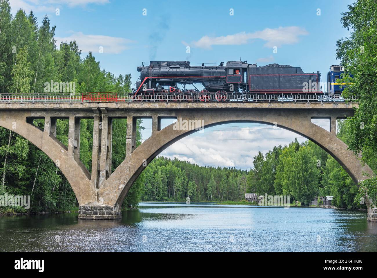 Retro steam train moves above the river Stock Photo - Alamy