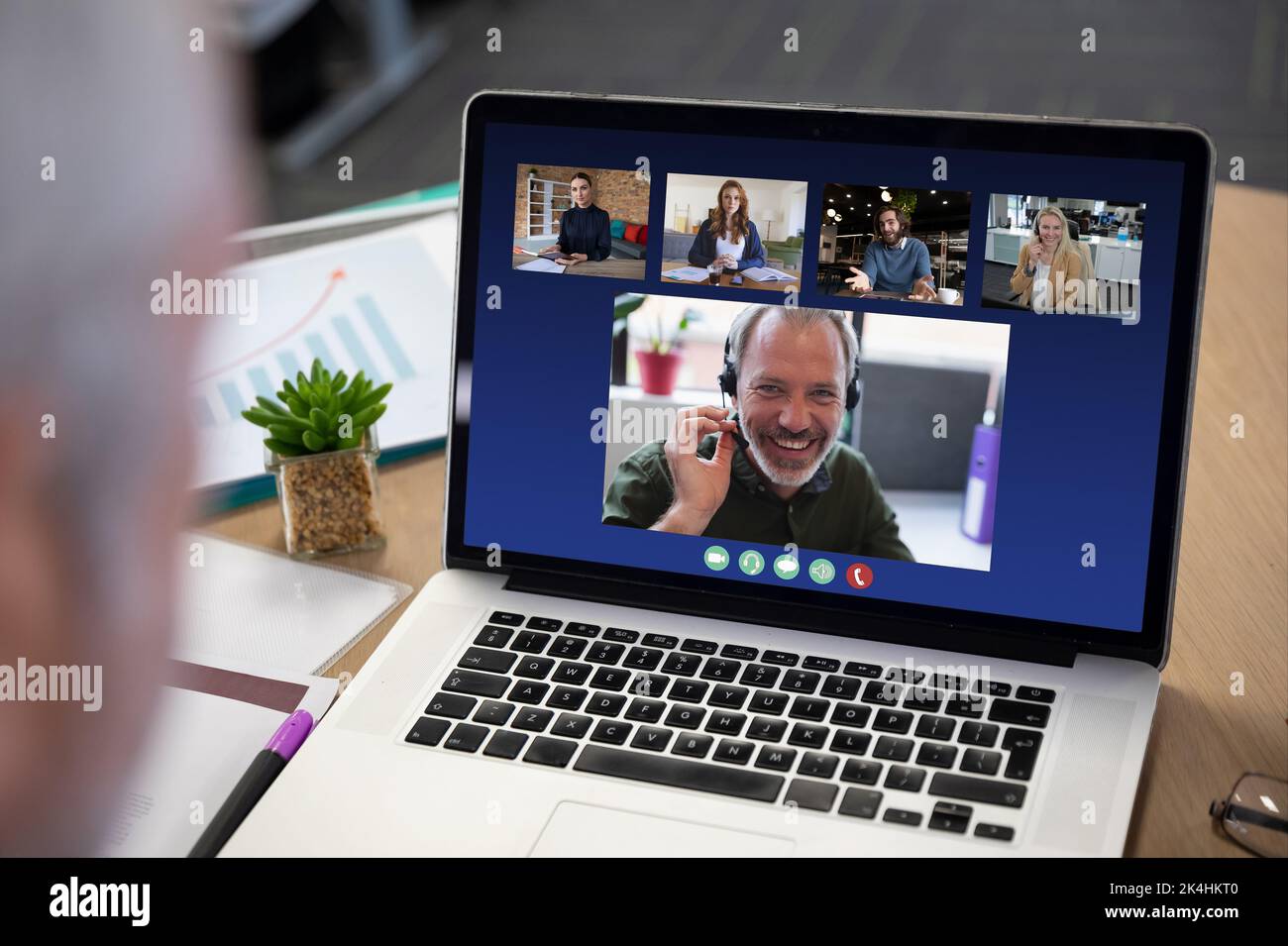 Diverse business people displayed on laptop screen during office video ...