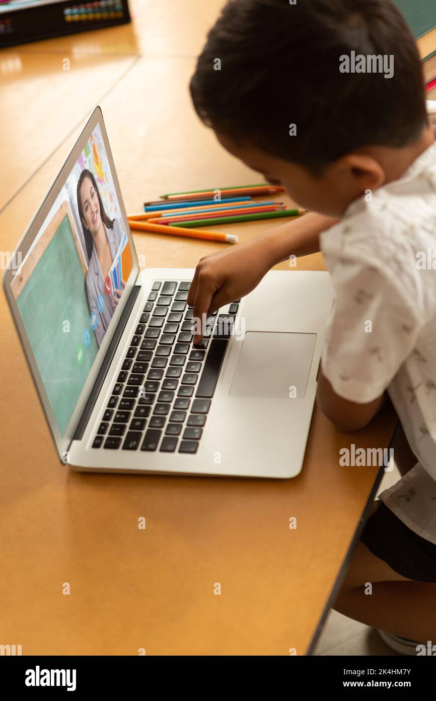 Male student having a video call with female teacher on laptop at ...