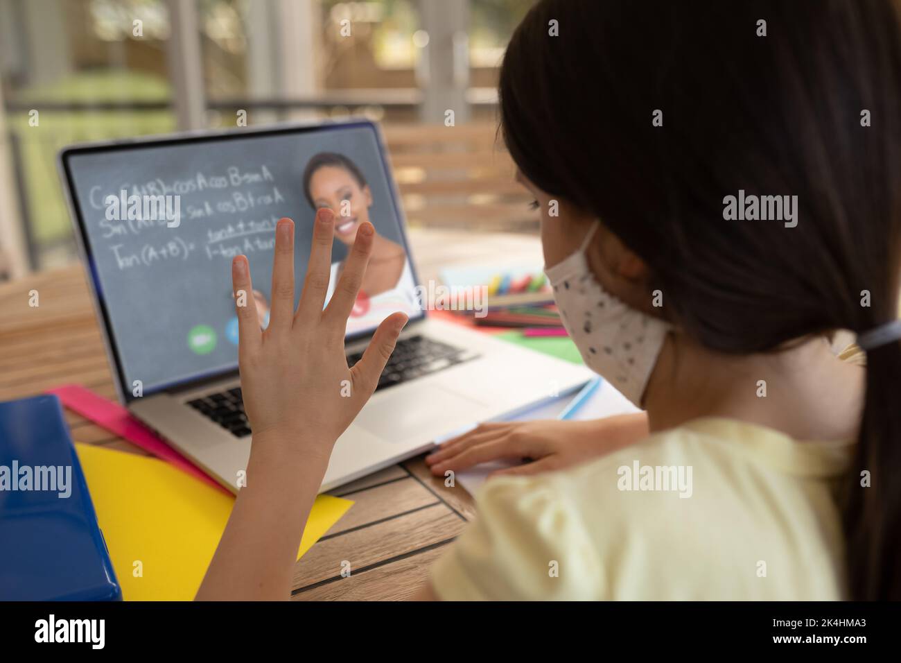 Female student wearing face mask having a video call with female ...