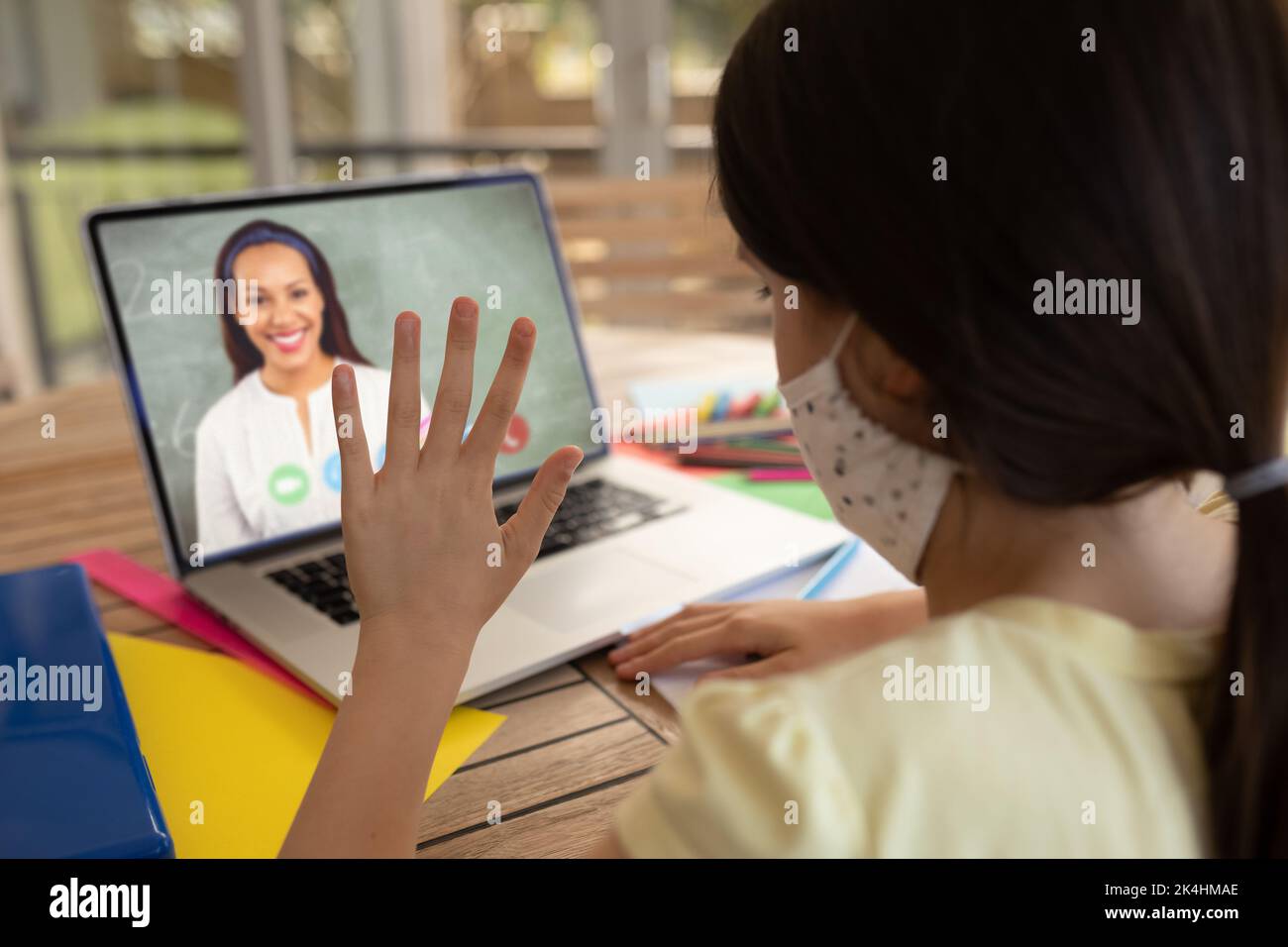 Female student wearing face mask having a video call with female ...