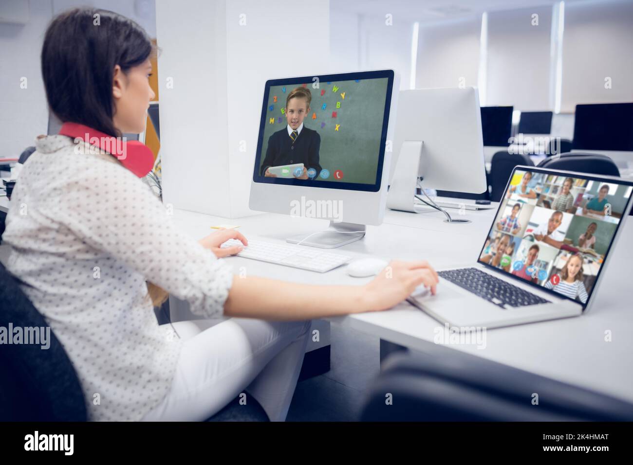 Female teacher wearing headphones having a video call with multiple ...