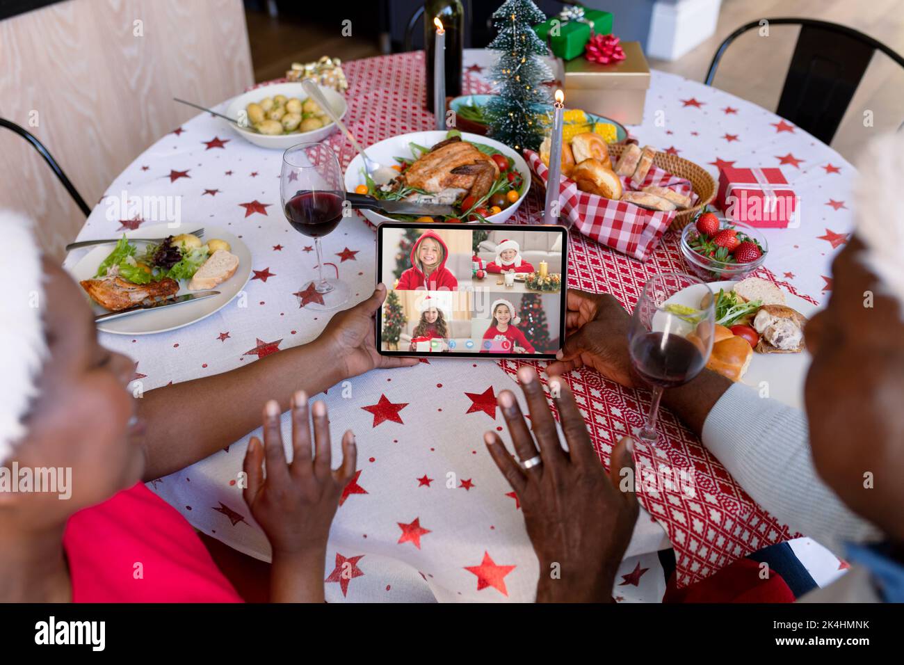 Waving african american couple in santa hats making christmas tablet ...