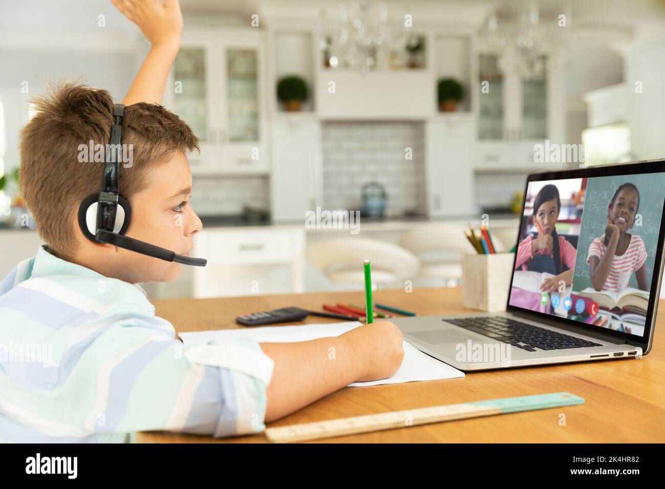 Caucasian boy raising hand for video call, with smiling diverse ...