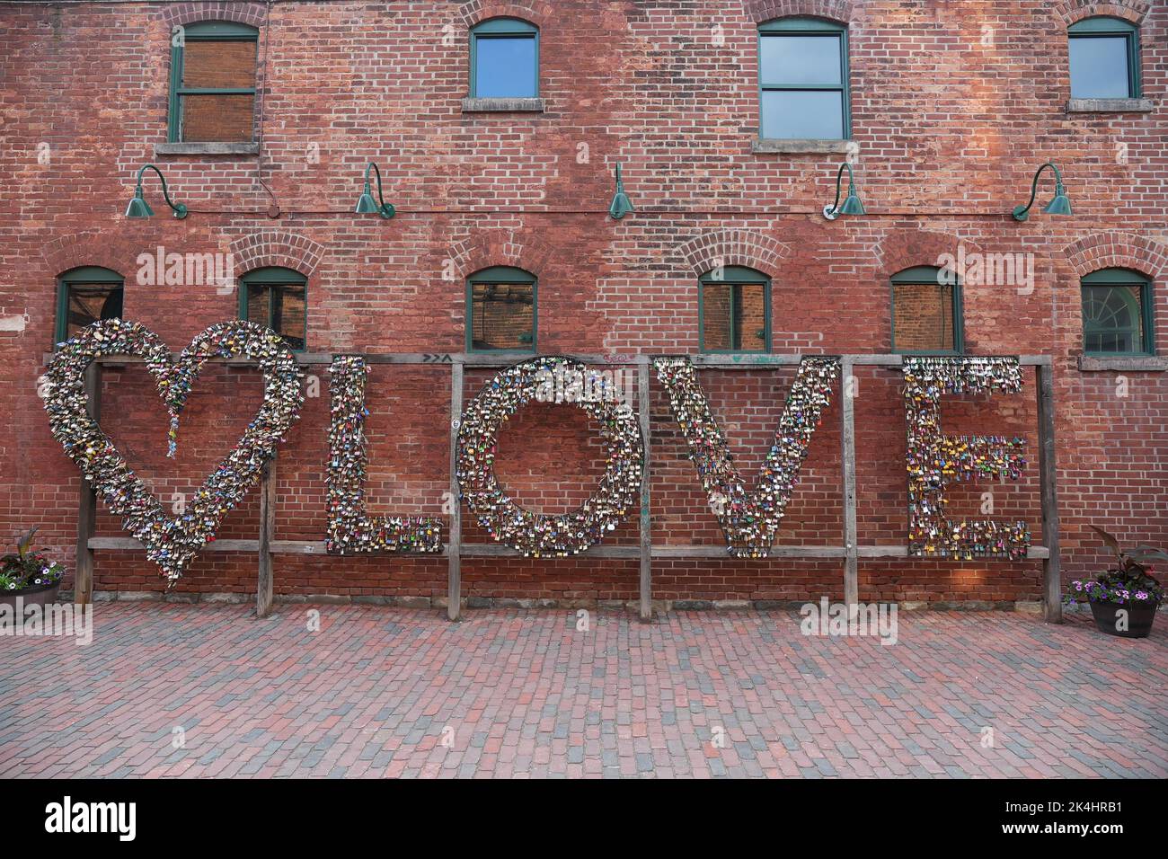 Love sign created from padlocks on a brick wall of an old industrial ...