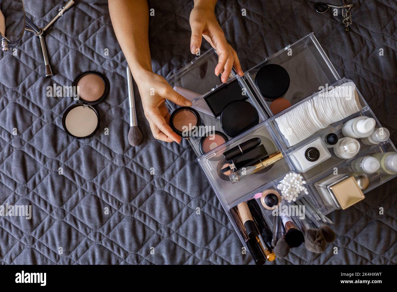 Woman hands tidying up putting powder container into acrylic storage ...