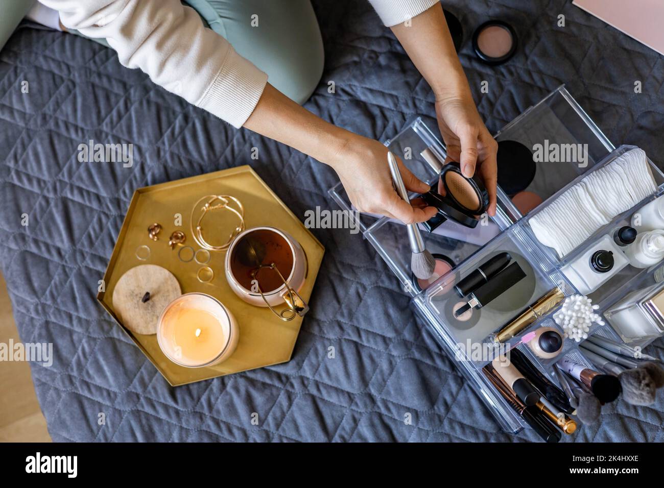 Woman hands tidying up putting powder container into acrylic storage ...
