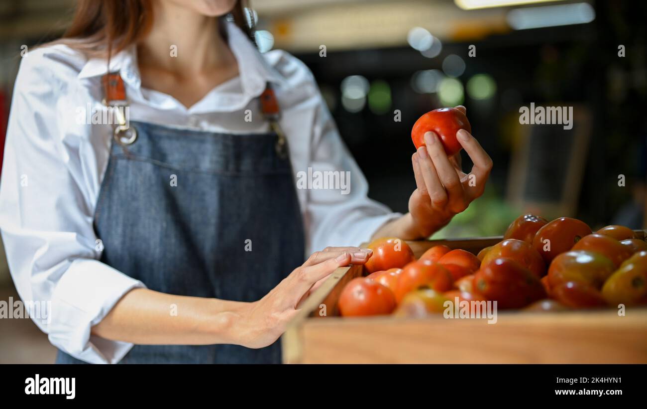 Beautiful Asian female small local grocery store owner arranging her ...