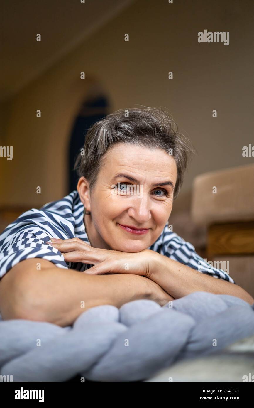 Portrait smiling middle aged gray haired woman posing with hands near ...