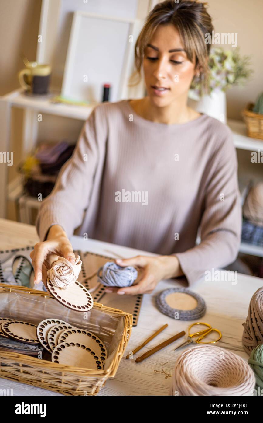 Top view woman hands knitted accessory interior decor use ribbon yarn ...
