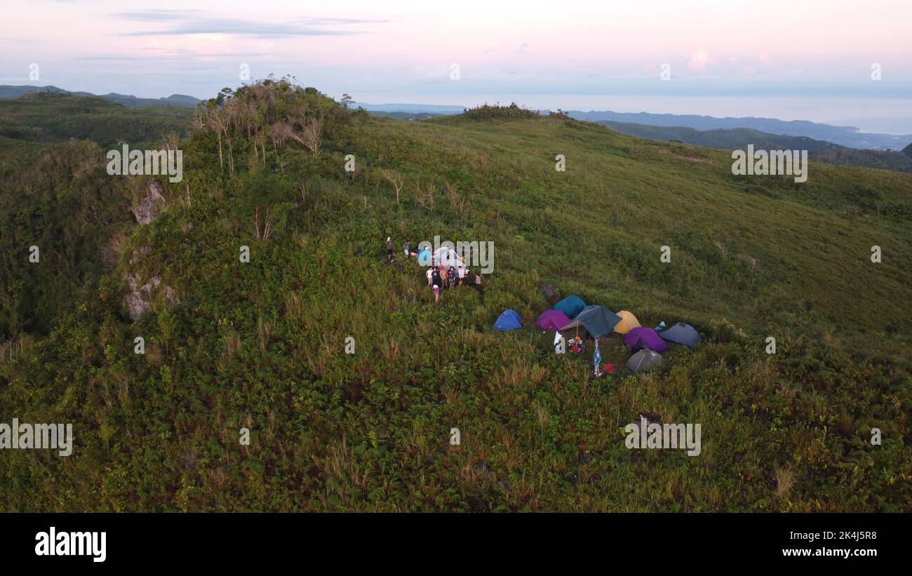 A group of colorful tents on the peak of the green hills Stock Photo ...