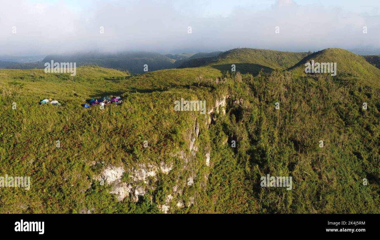 A group of colorful tents on the peak of the green hills Stock Photo ...