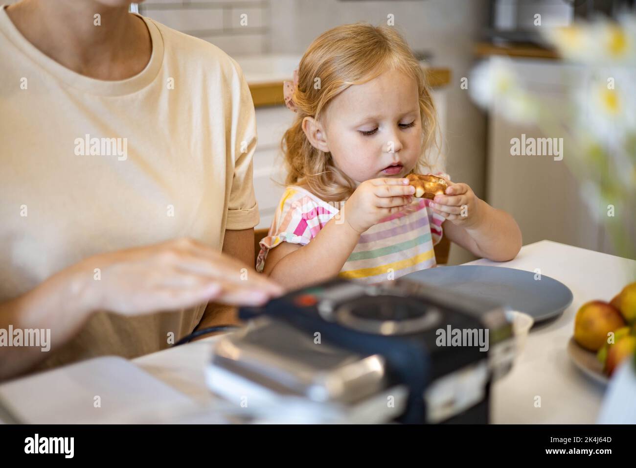 Cute little girl eating fresh cooking homemade waffles enjoying family ...