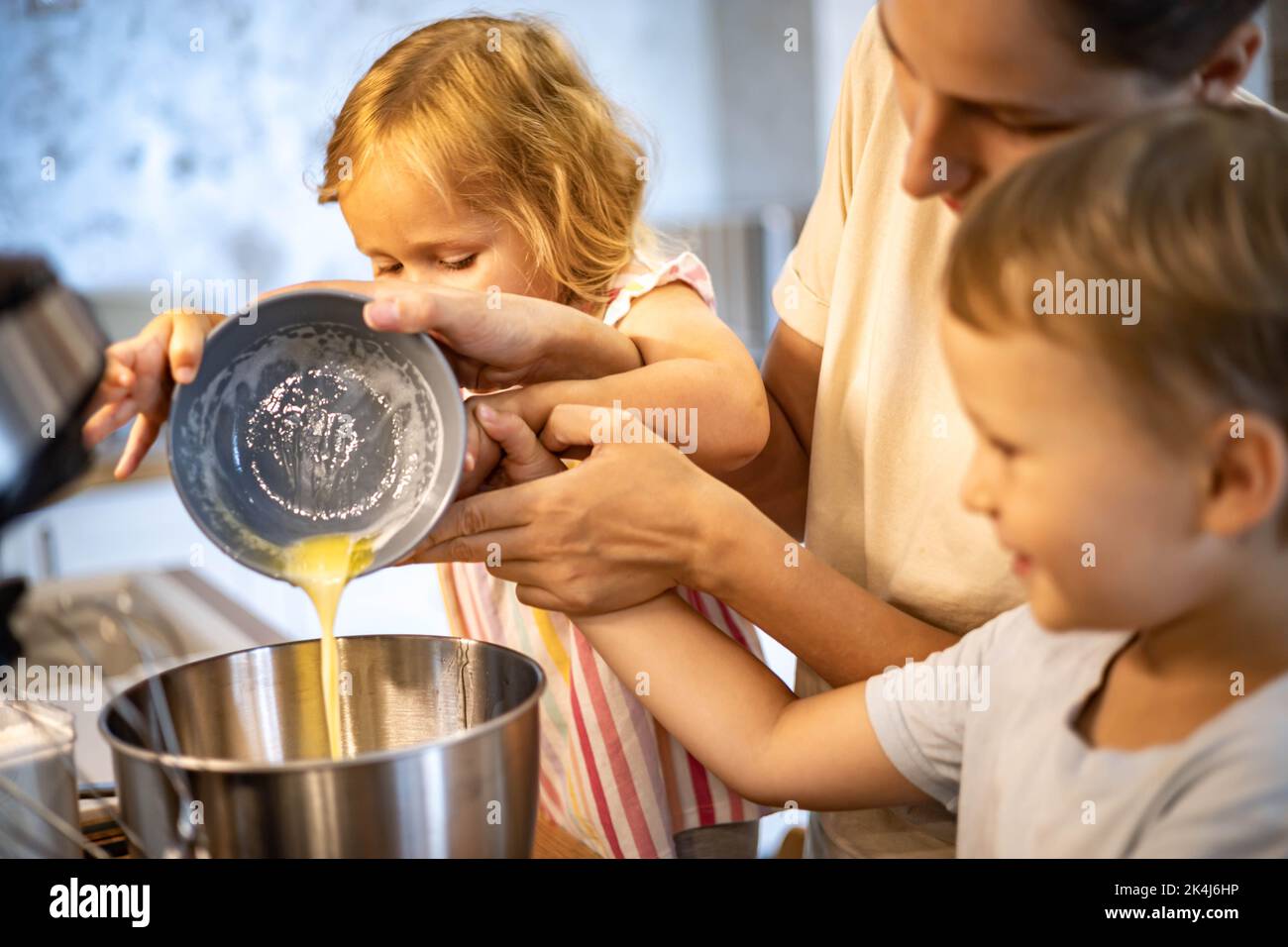 Caring mother cooking with daughter and son together family preparing ...