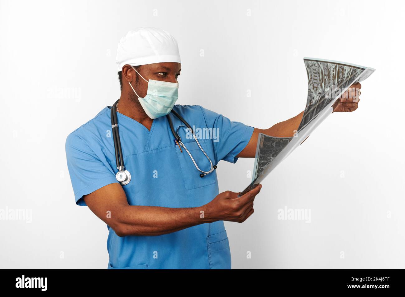 Black surgeon doctor man in blue coat white cap and surgeon mask holds ...